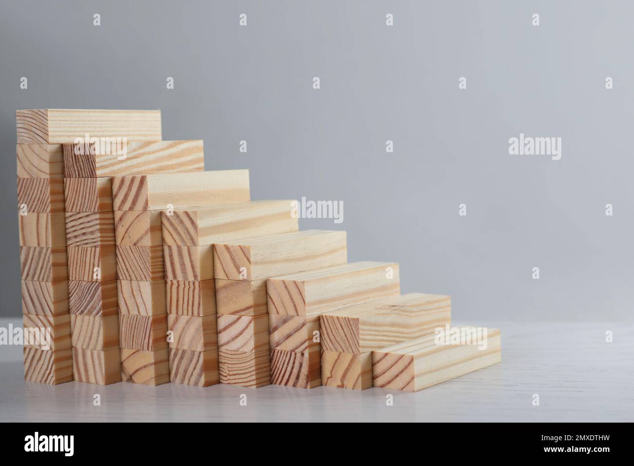 Steps made with wooden blocks on light background, space for text ...