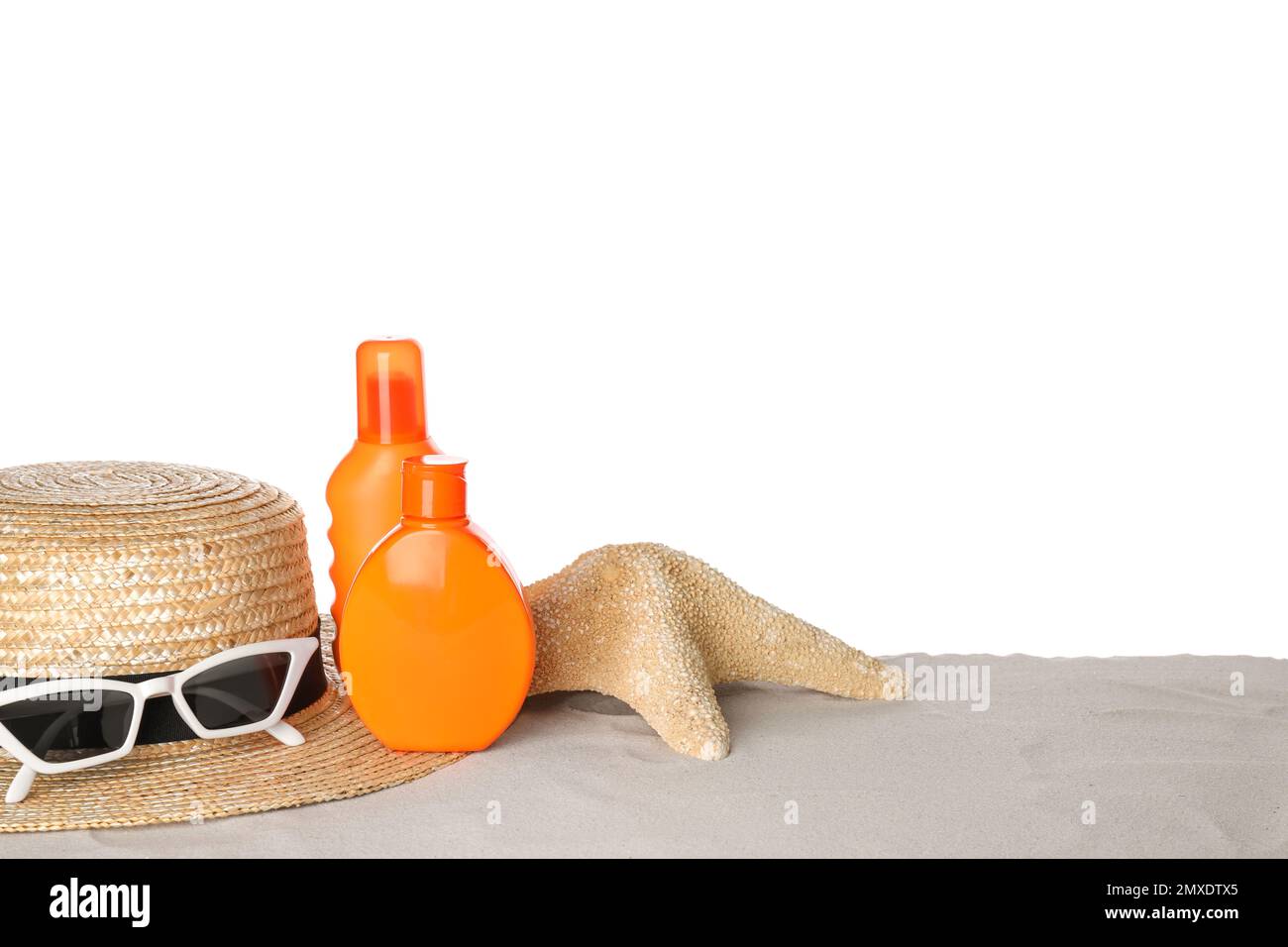 Composition with sun protection products on sand against white ...