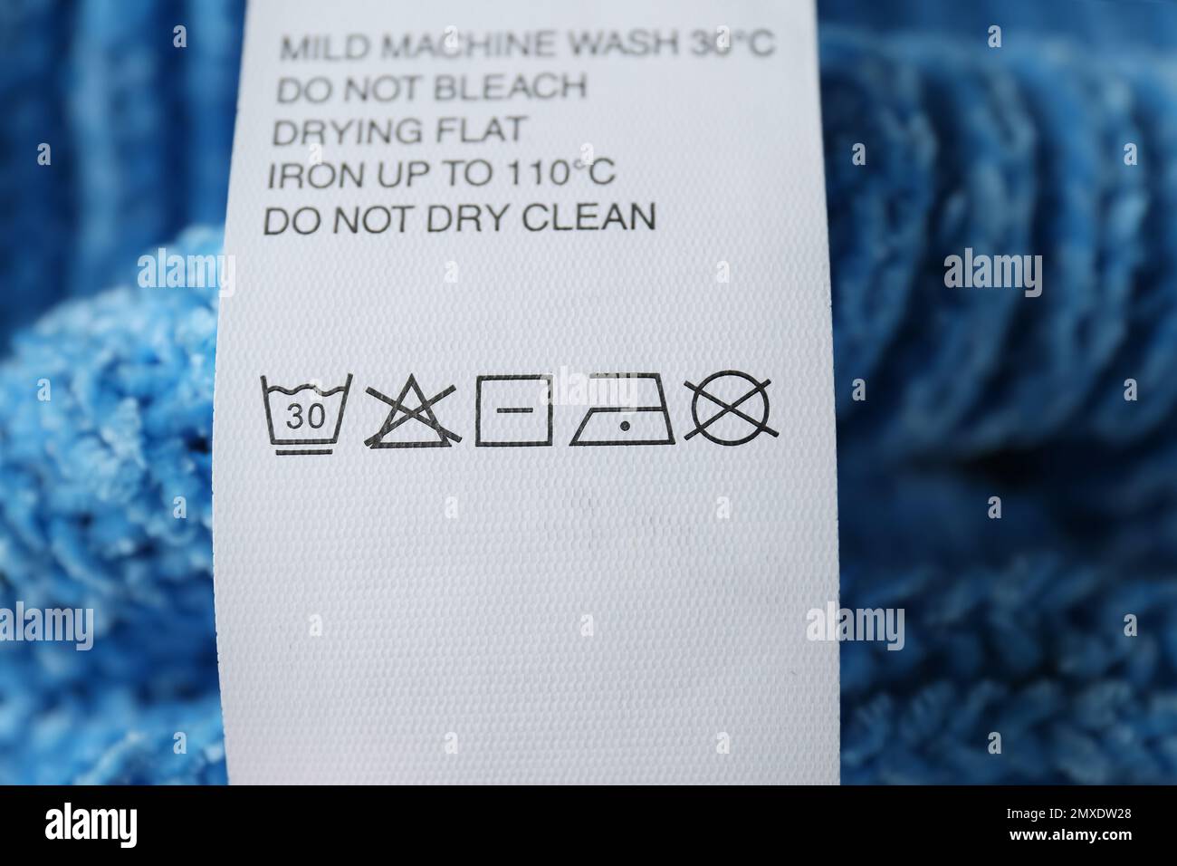 Clothing label with care symbols on blue sweater, closeup view Stock ...