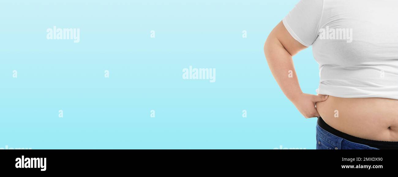 Closeup view of overweight woman on light blue background, space for ...