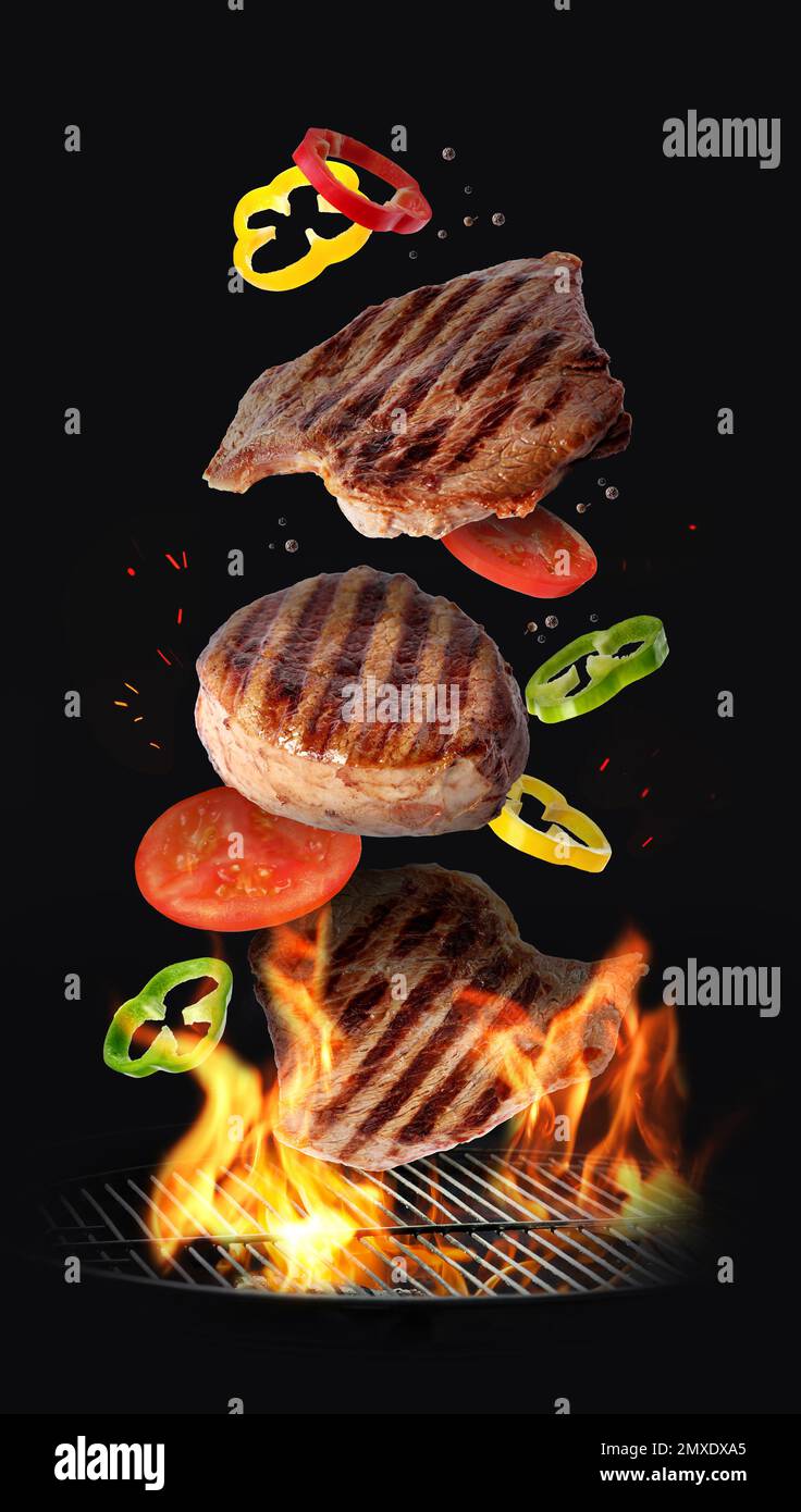 Tasty roasted meat and vegetables falling on barbecue grill with ...