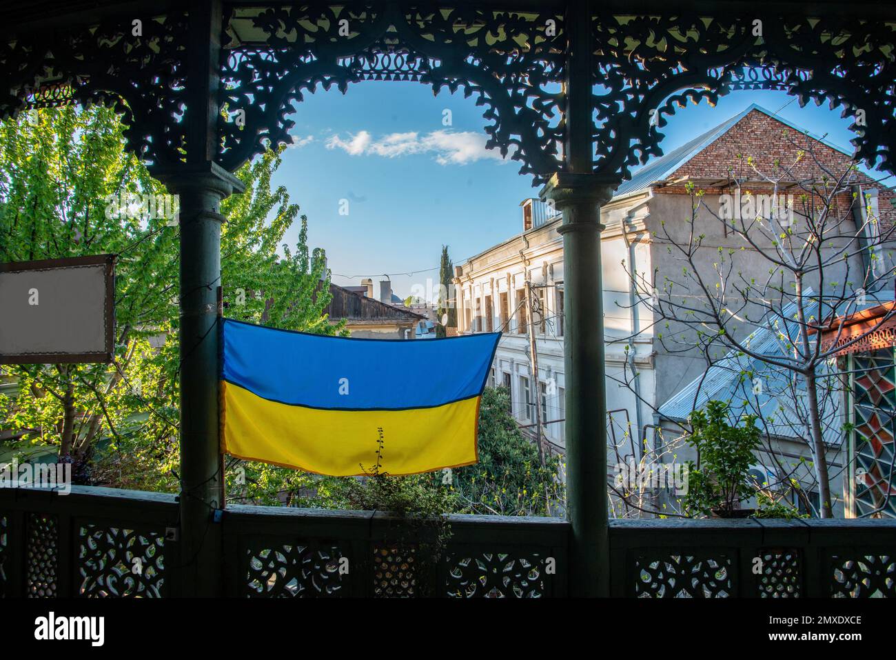 Wooden Georgian veranda and Ukrainian flag on it (support for Ukraine ...