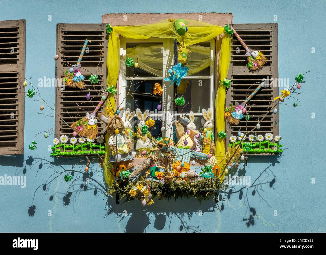 Easter ornaments with bunnies and eggs at the window of a house in the ...