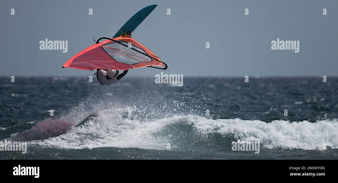 Windsurfer jumping over a big wave balancing in the sky Stock Photo - Alamy