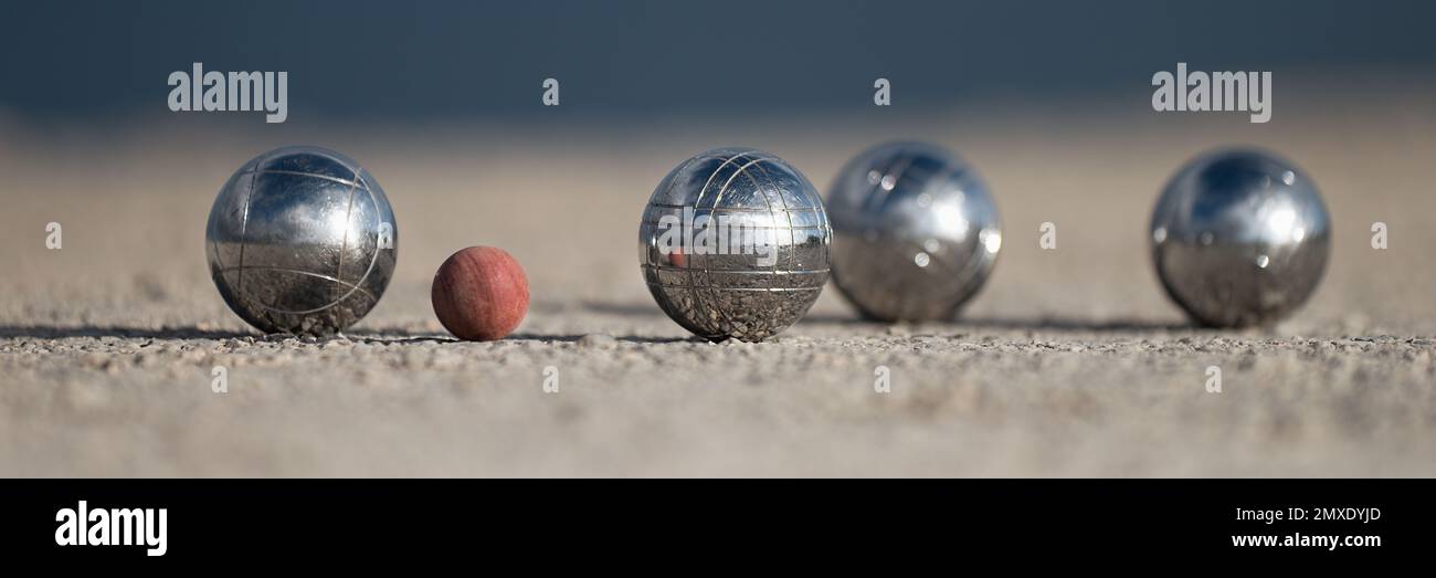 Metallic petanque four balls and a small wood jack Stock Photo - Alamy
