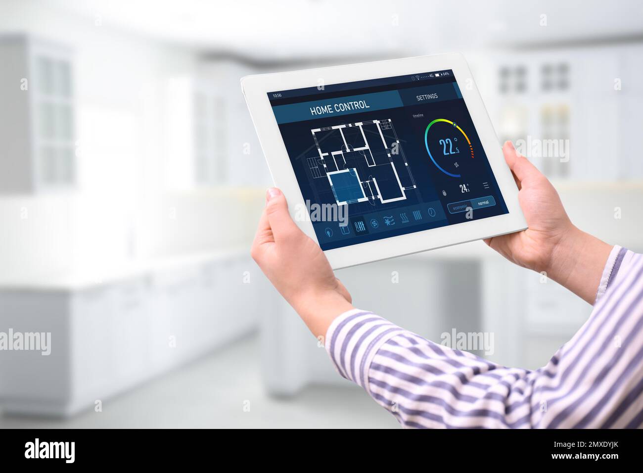Energy efficiency home control system. Woman using tablet to set indoor ...