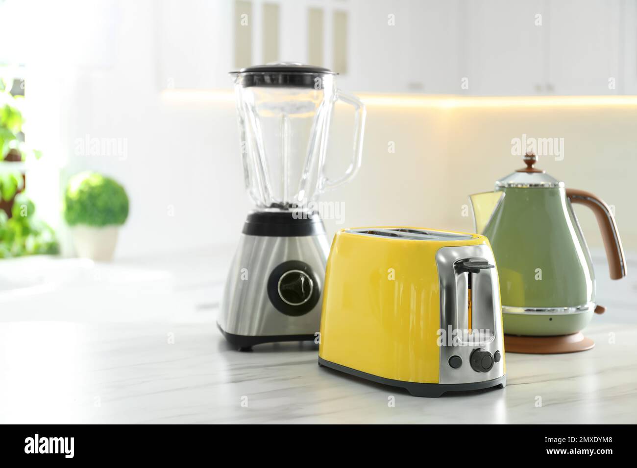 Set of modern home appliances on white marble table in kitchen Stock ...