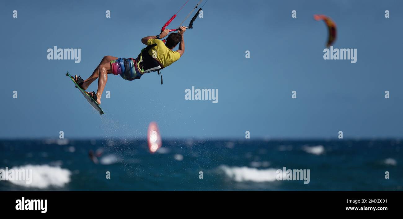 Athletic man jump on kite surf board on a sea waves, kiteboarding ...