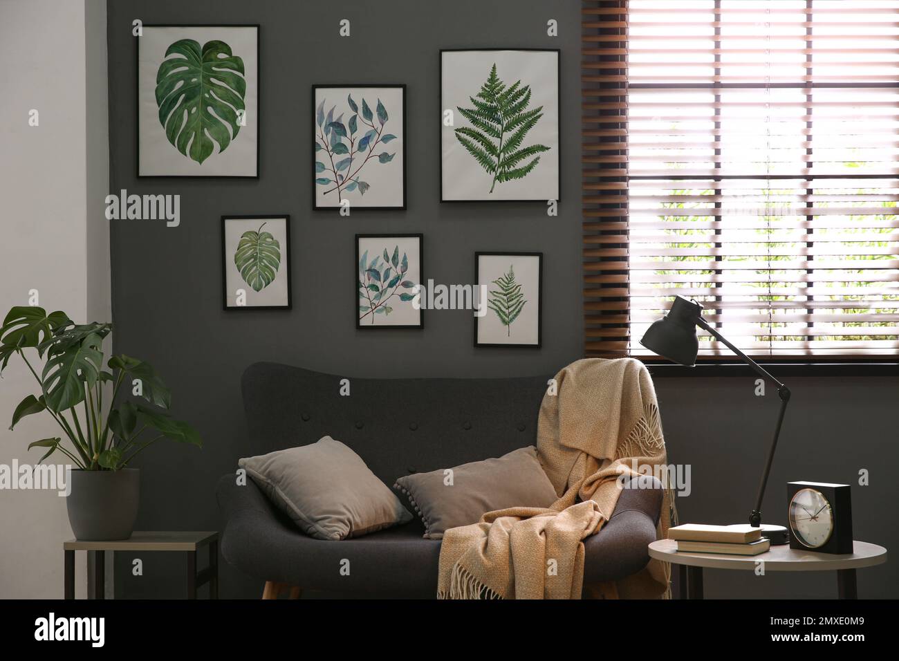 Beautiful artworks and comfortable sofa in stylish room. Interior ...