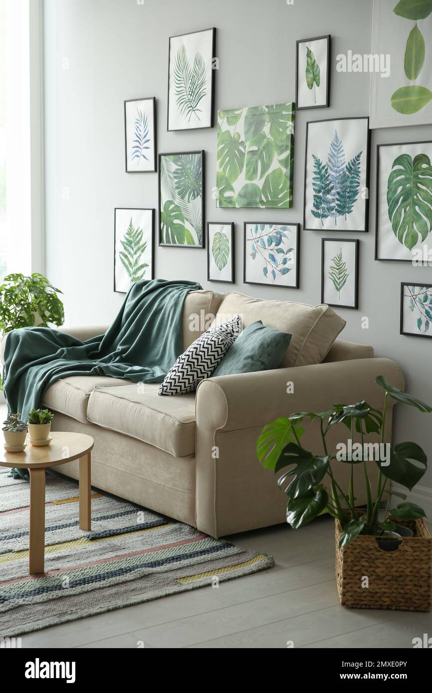 Beautiful artworks and comfortable couch in stylish room. Interior ...