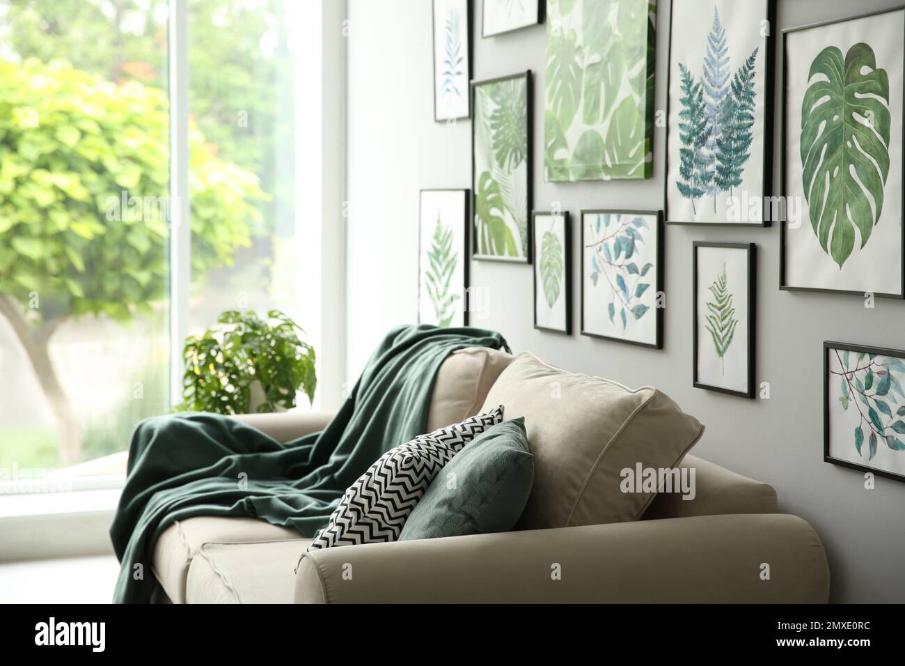 Beautiful artworks and comfortable couch in stylish room. Interior ...