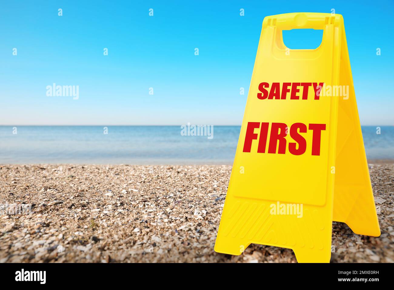 Sign with phrase SAFETY FIRST on sandy beach, space for text Stock ...