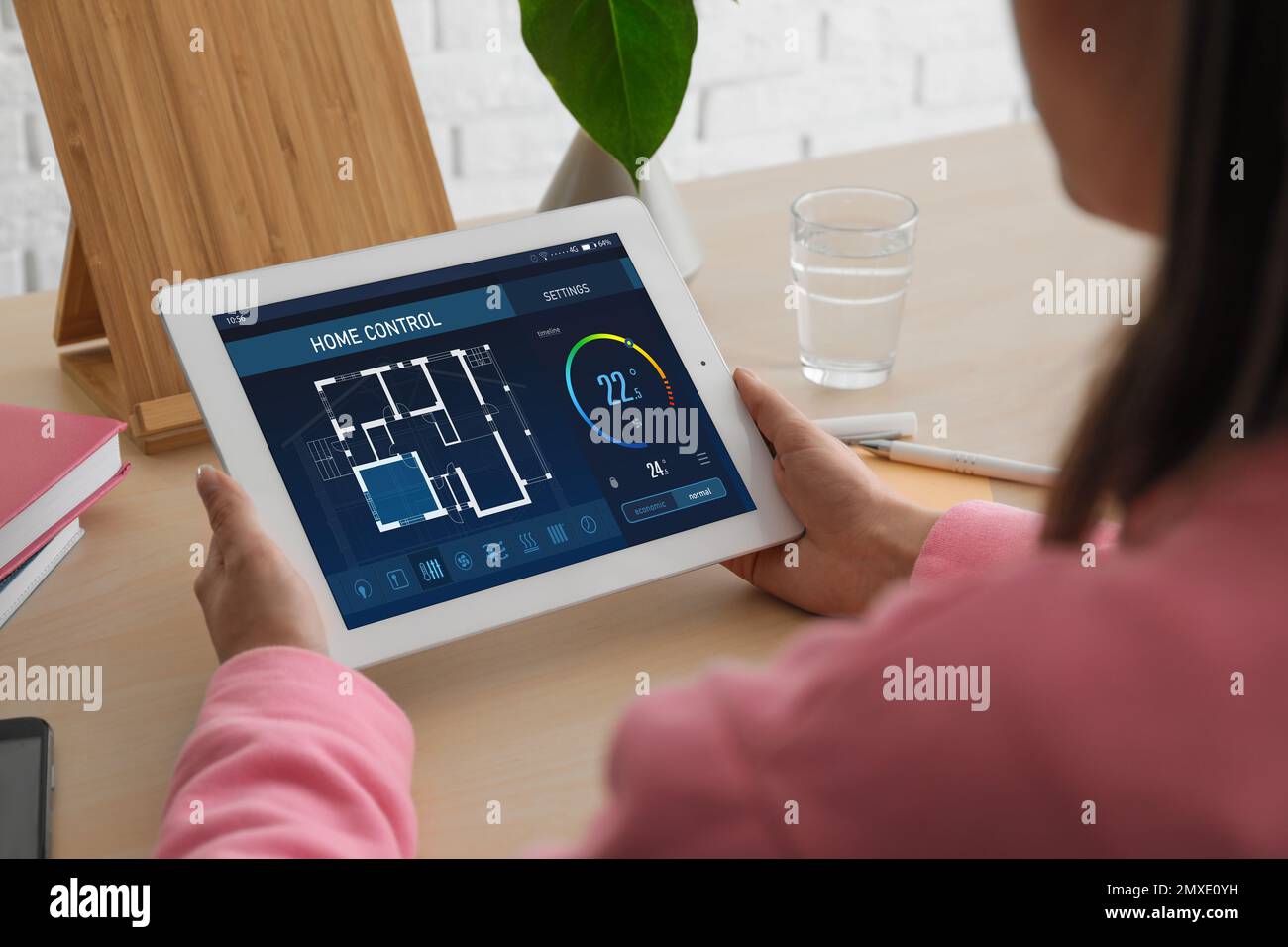 Energy efficiency home control system. Woman using tablet to set indoor ...
