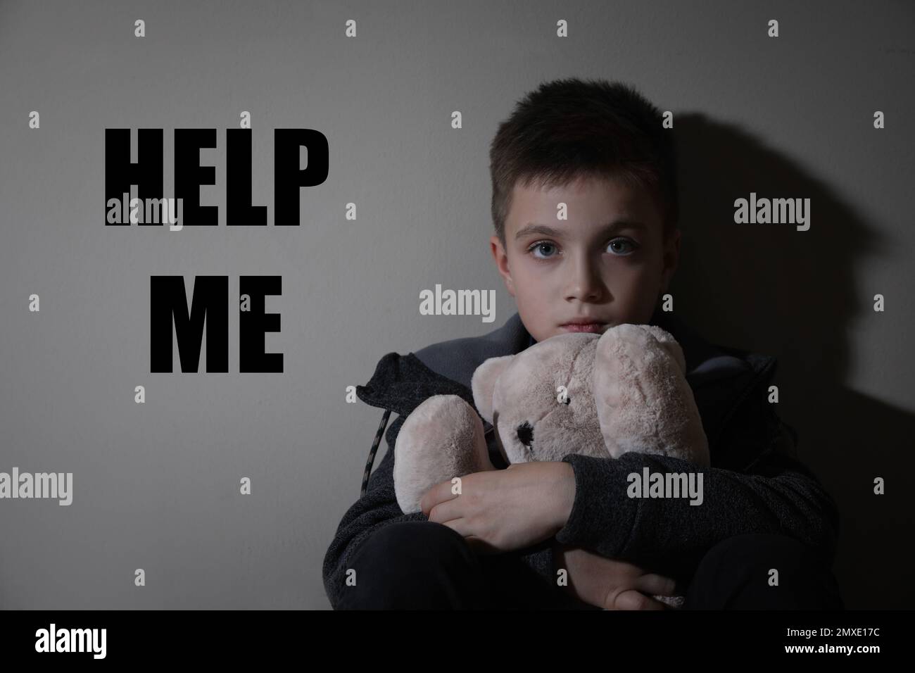 Sad little boy with teddy bear and text HELP ME on beige background ...