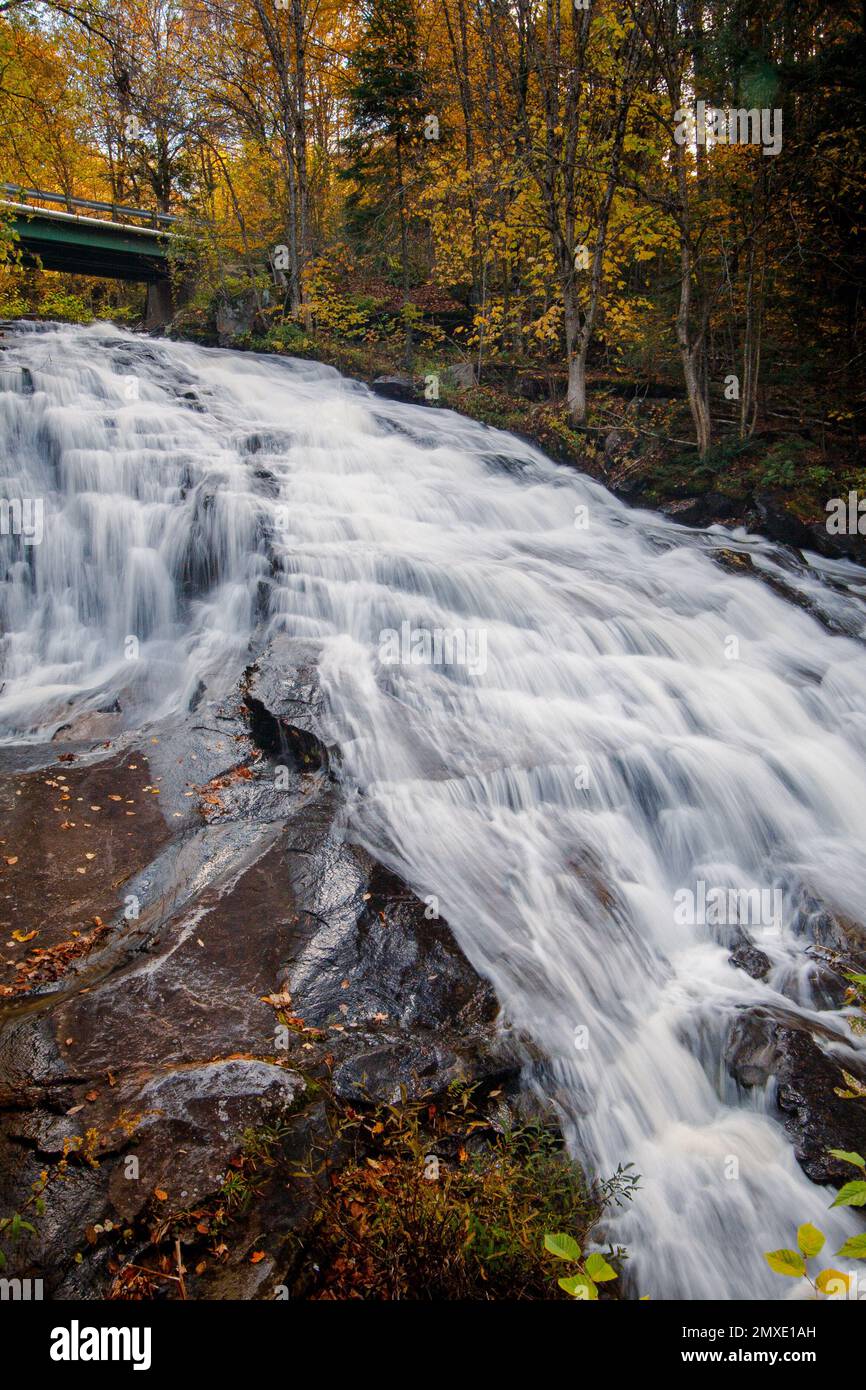 Rushing waterfall in northeast Vermont and fall foliage with highway ...