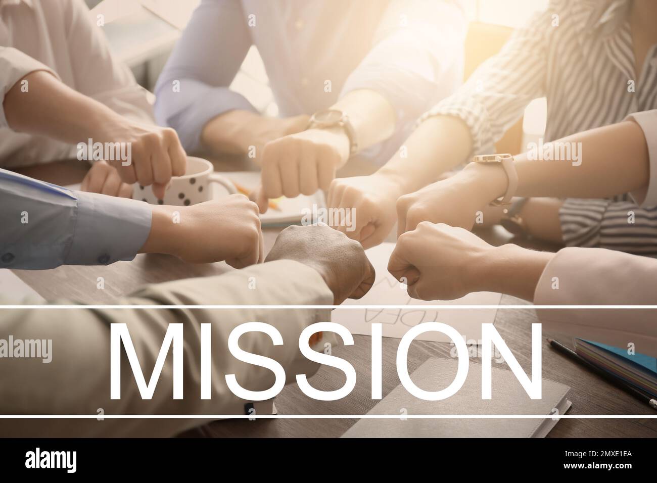 People putting hands together at table, closeup. Mission concept Stock ...