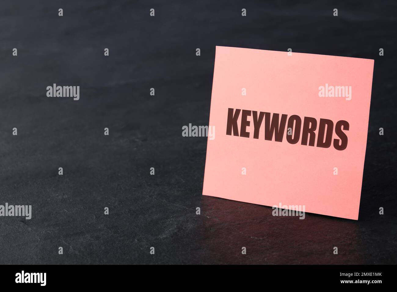 Note with phrase KEYWORDS on black stone table. Space for text Stock ...