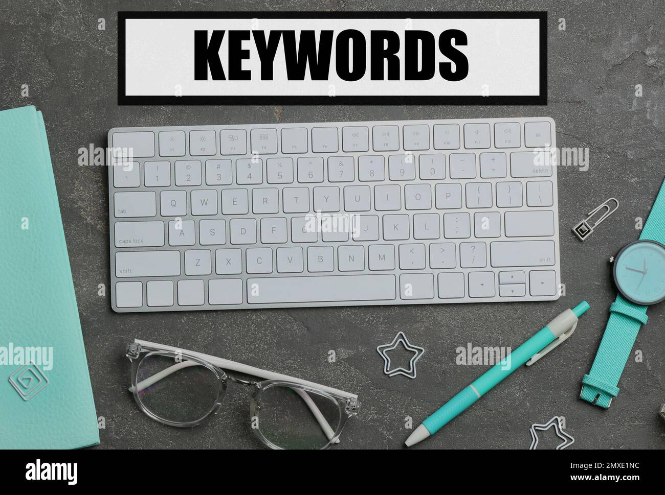 Flat lay composition with keyboard and text KEYWORDS on grey background ...