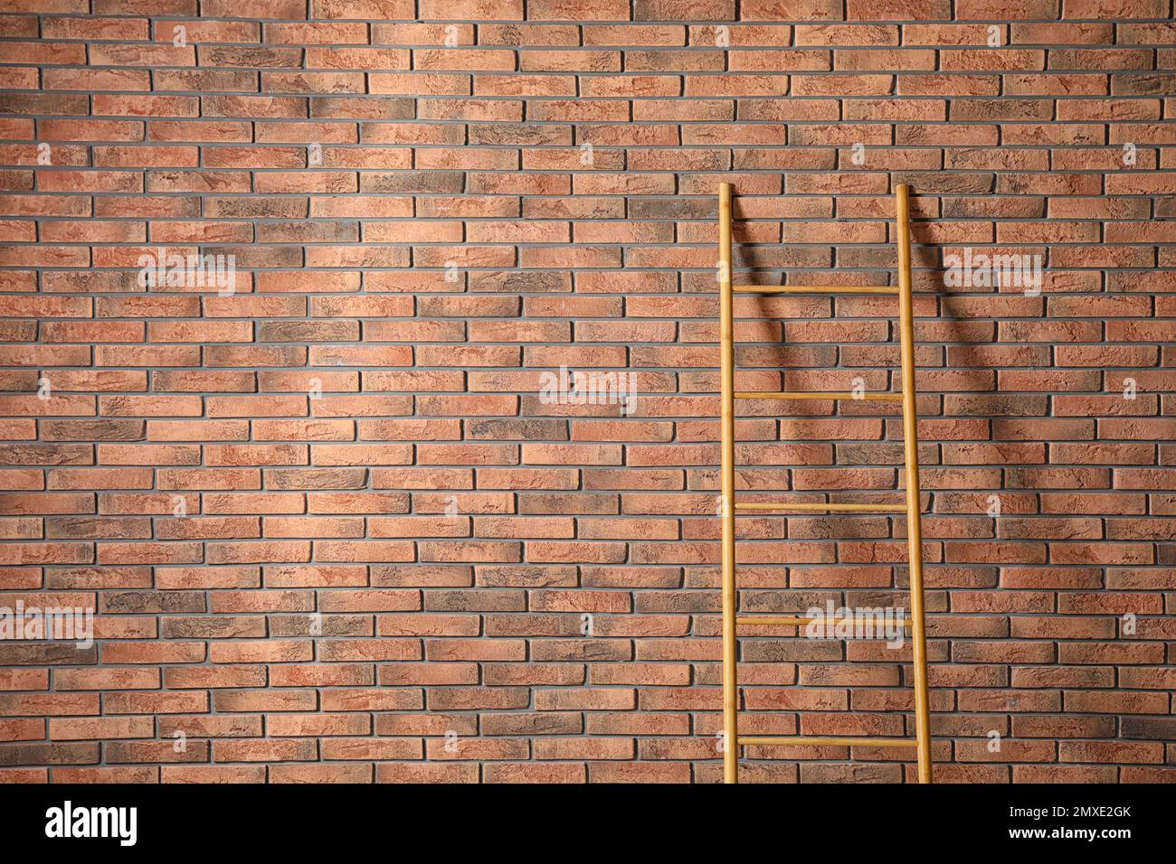 Modern wooden ladder near brick wall. Space for text Stock Photo - Alamy