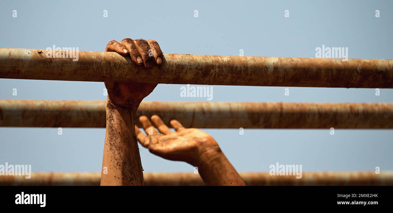 Mud race running over obstacles race runners, hands overcome obstacle ...