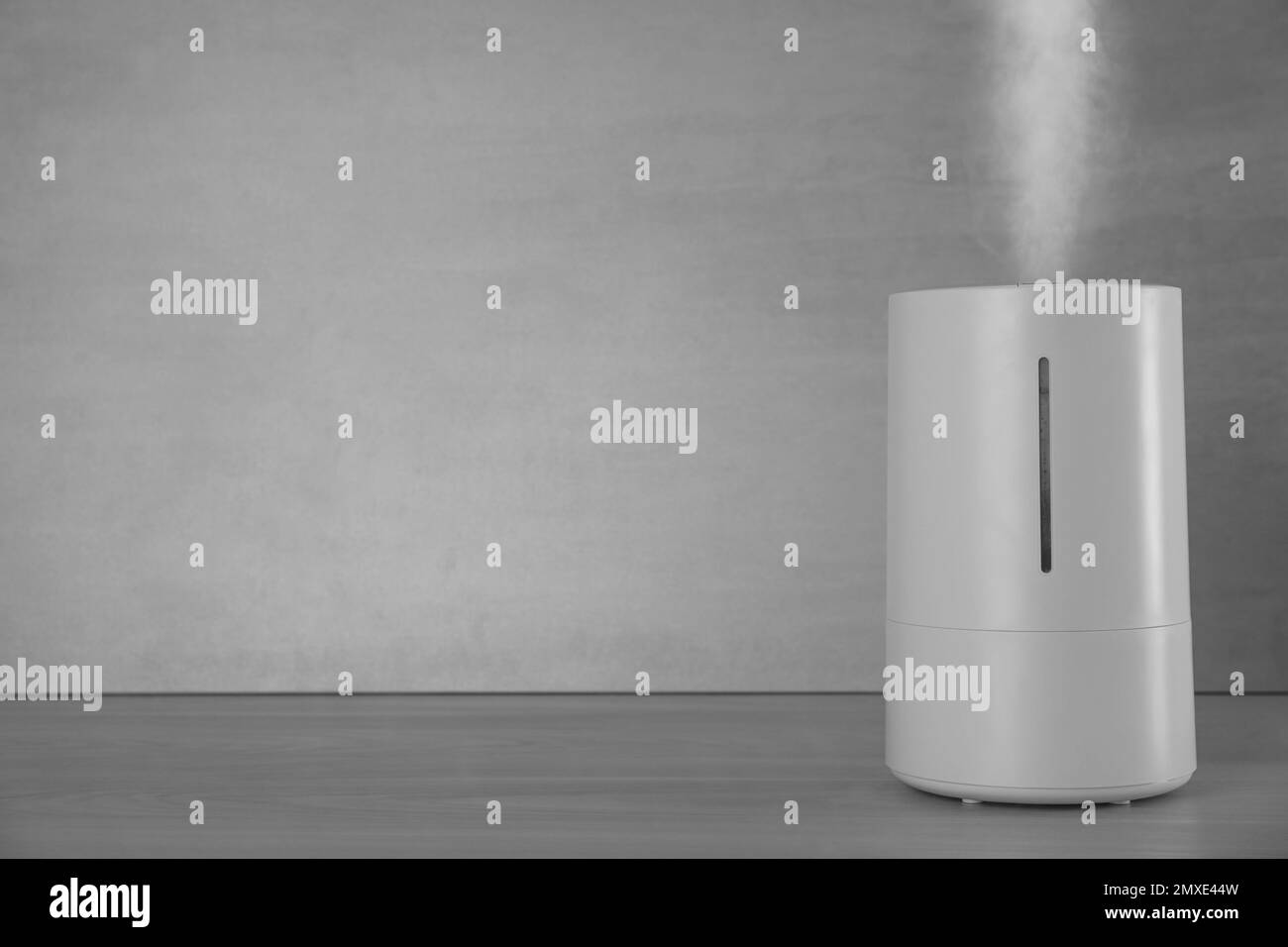 Modern air humidifier on table against grey background. Space for text ...
