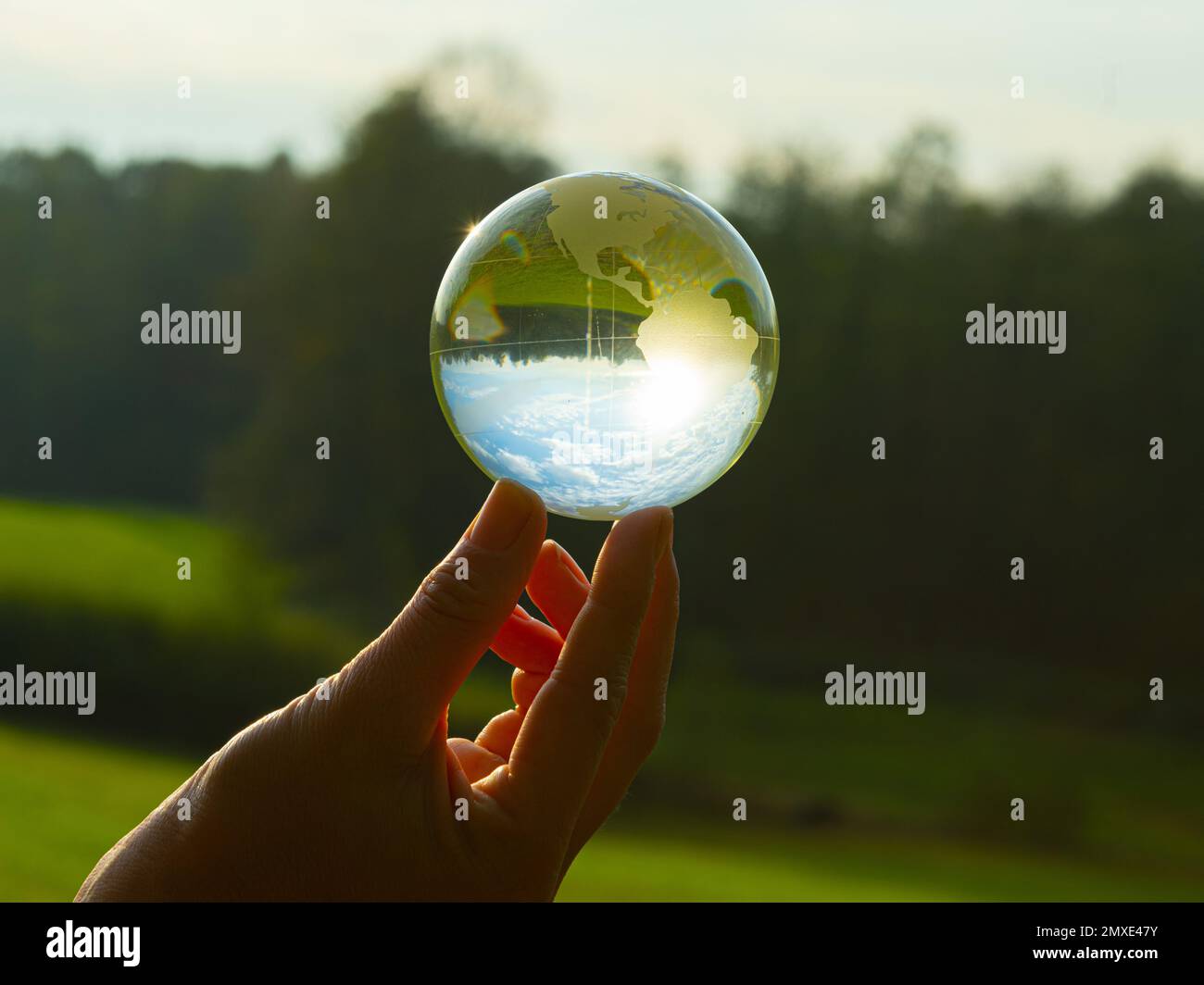 a hand holding up a transparent glass globe Stock Photo - Alamy