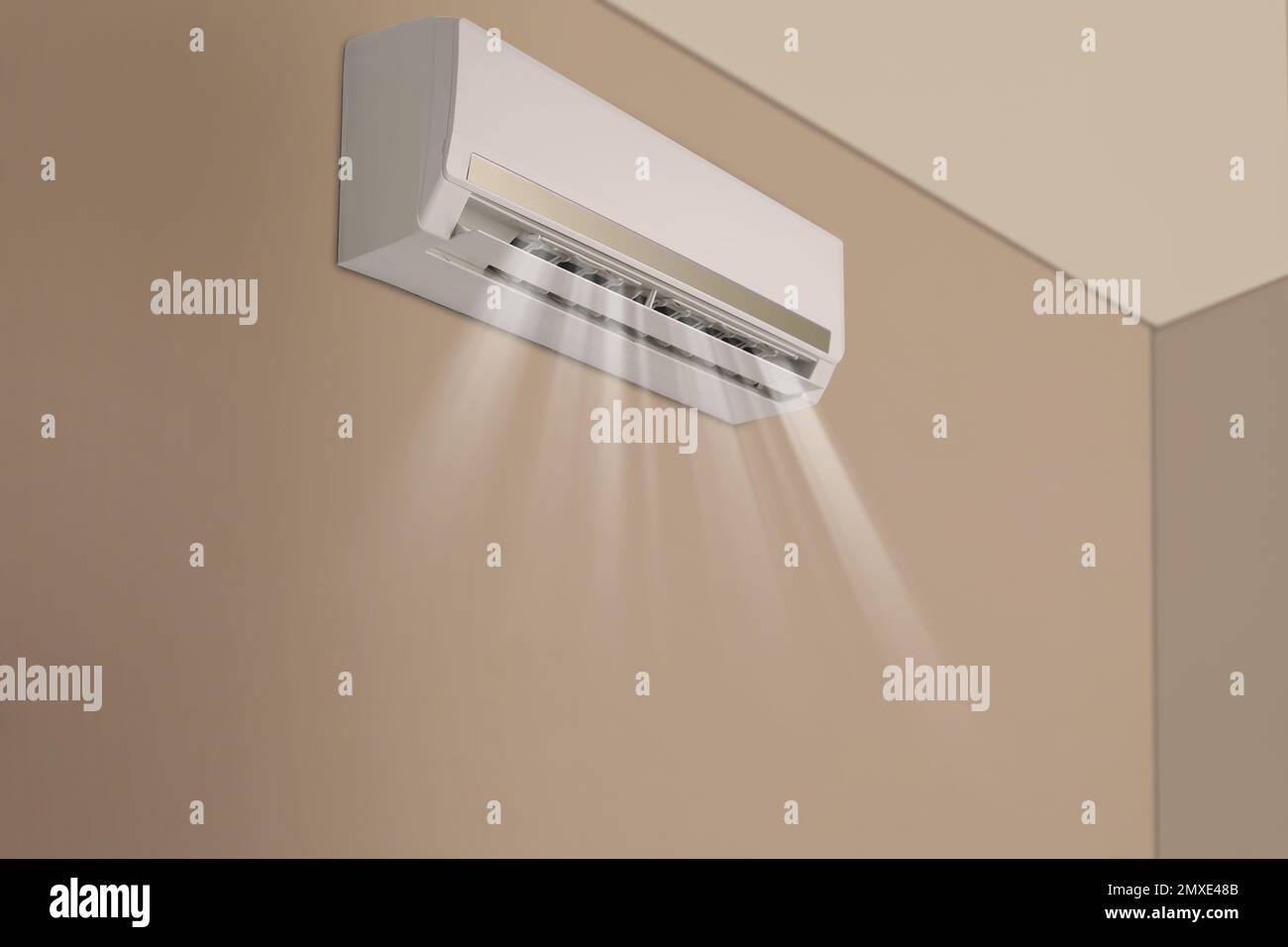Modern air conditioner on beige wall indoors Stock Photo - Alamy