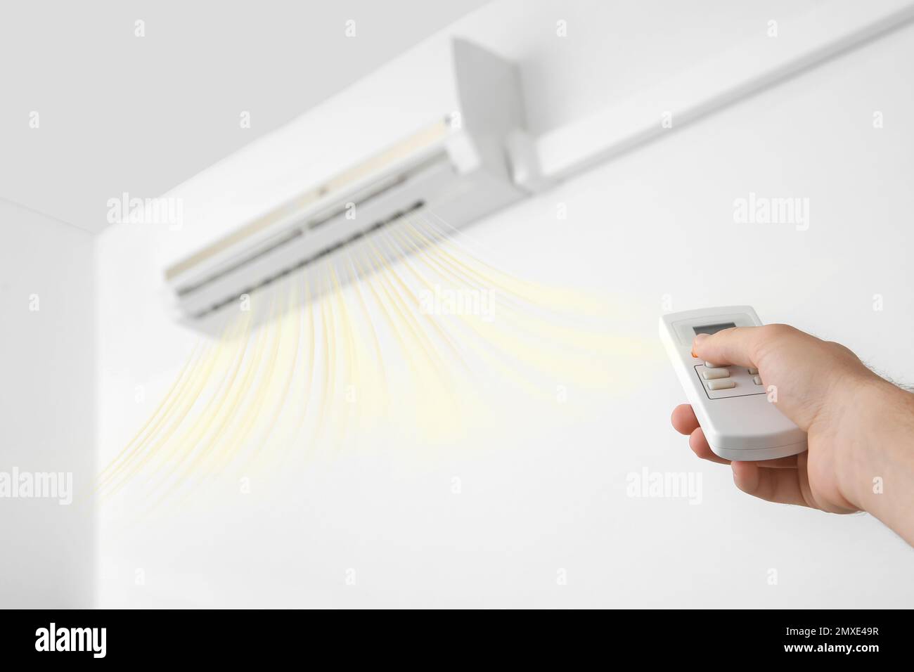 Woman operating air conditioner with remote control indoors, closeup ...