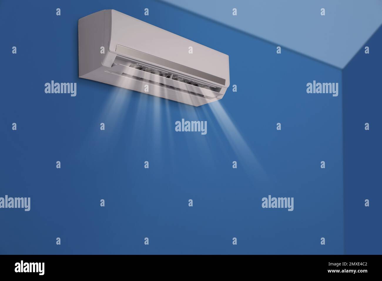 Modern air conditioner on blue wall indoors Stock Photo - Alamy