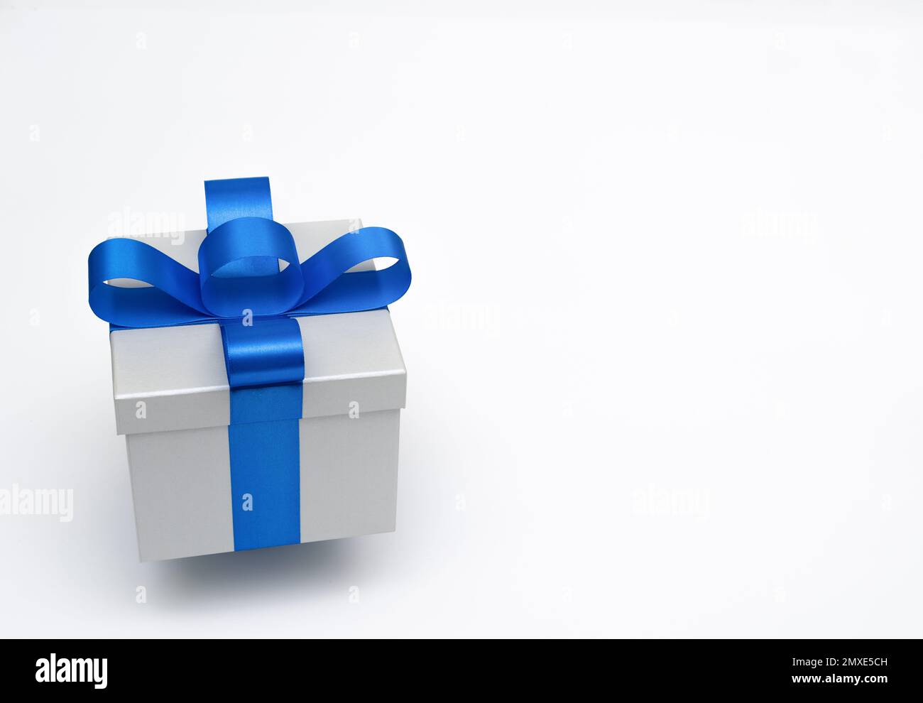 silver gift box with blue satin bow ribbon on white background.concept ...