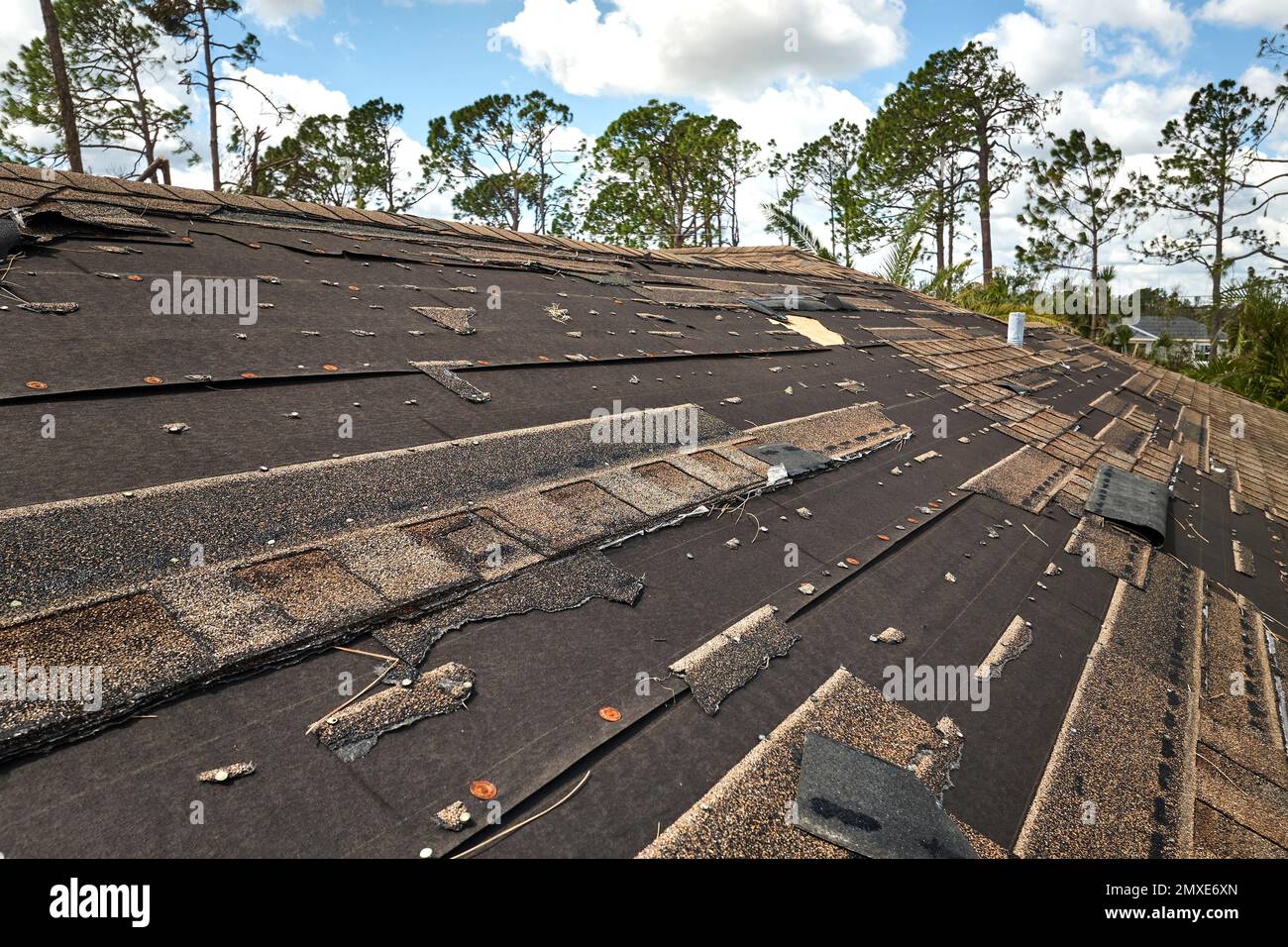 Damaged house roof with missing shingles after hurricane Ian in Florida ...