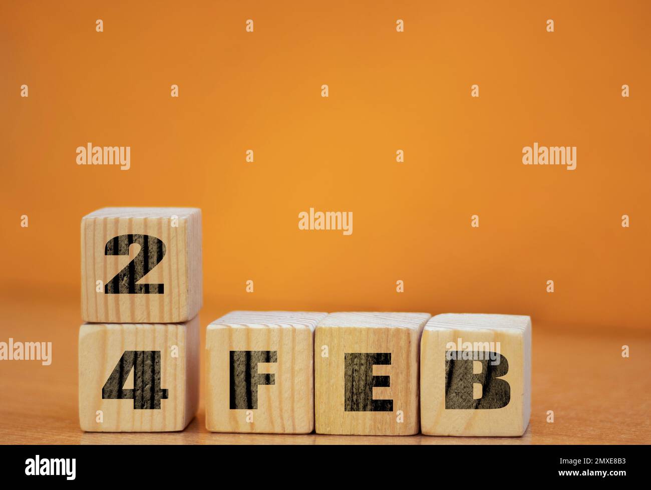 Cube shape calendar for february 24 on wooden surface with empty space ...