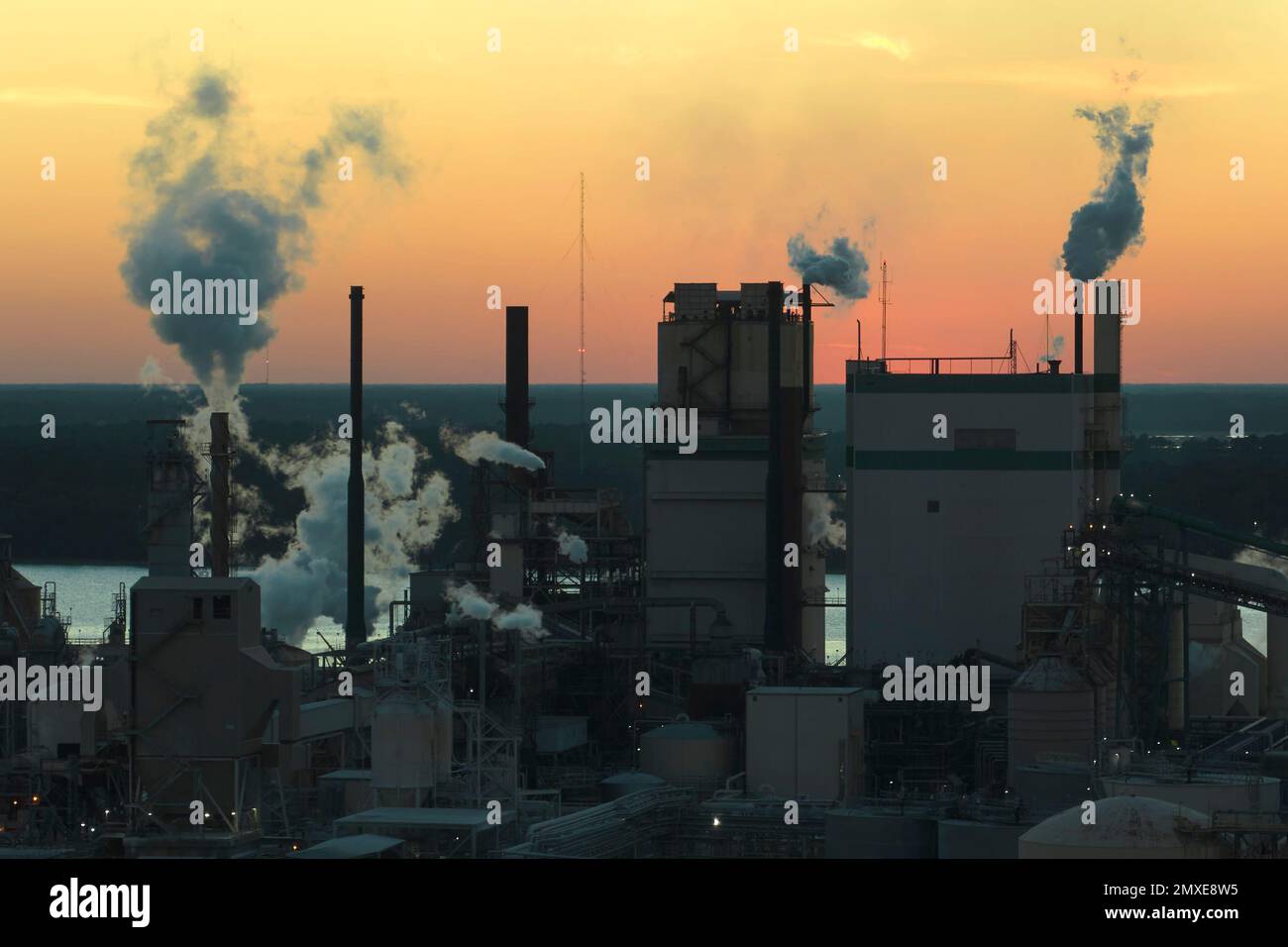 Large factory structure with smoke from production process rising up ...