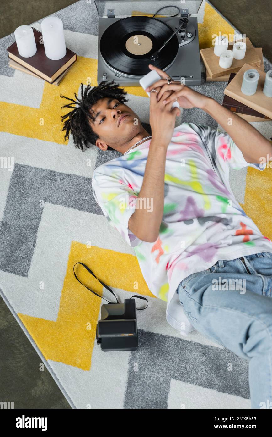 Top view of african american artist using smartphone near vintage ...