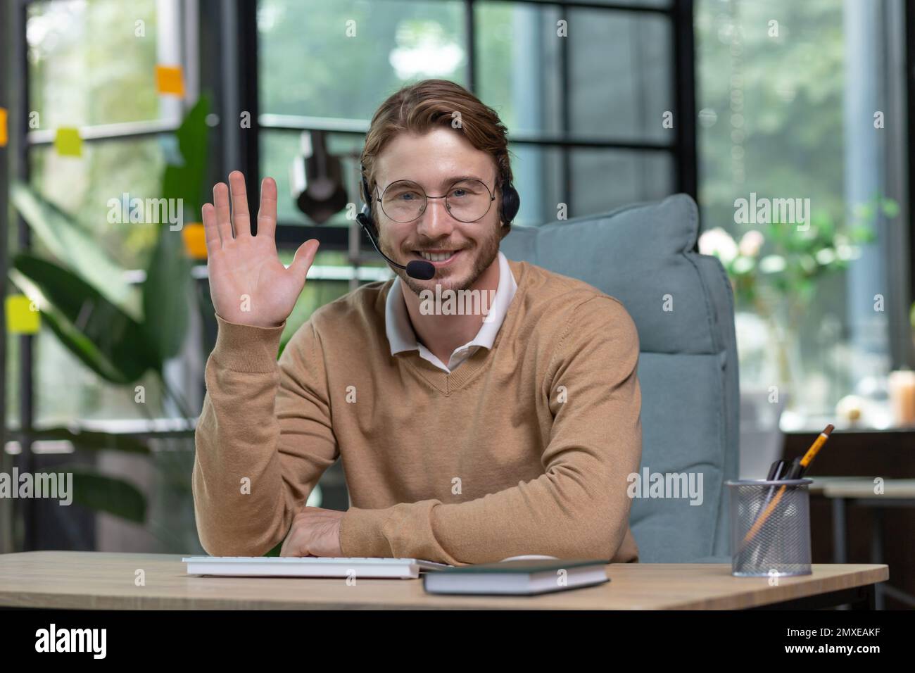 Smiling blond man waving camera hi-res stock photography and images - Alamy
