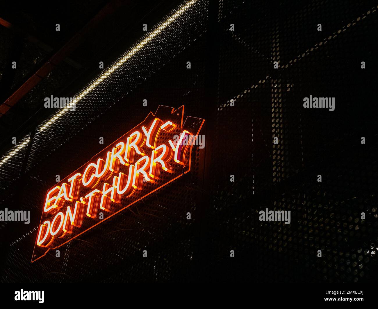 Neon inscription eat curry don't hurry,attracting visitors to Indian ...