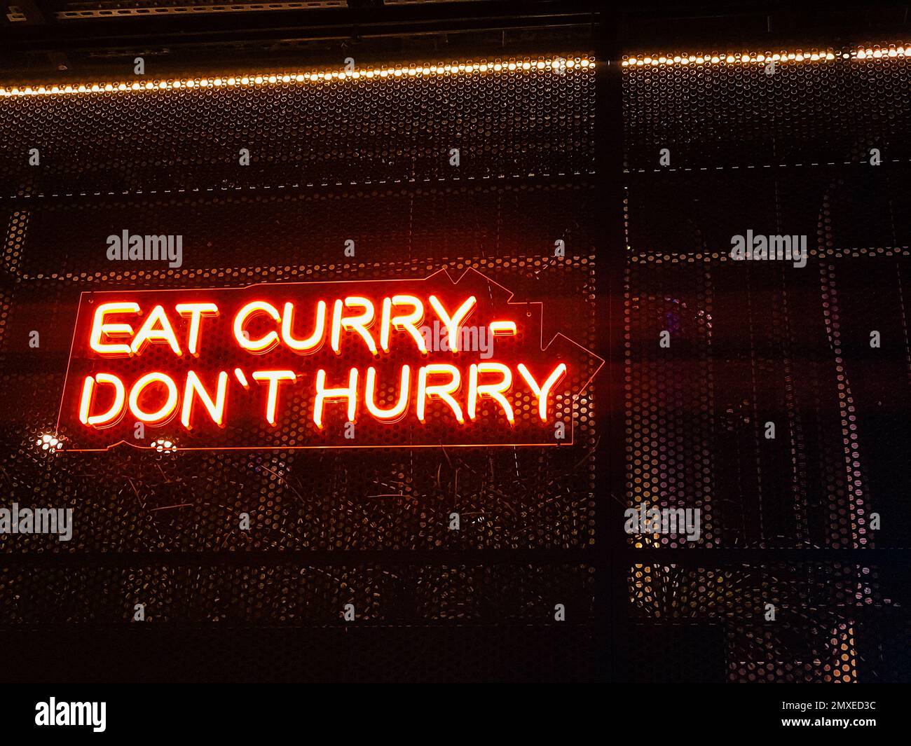 Neon inscription eat curry don't hurry,attracting visitors to Indian ...