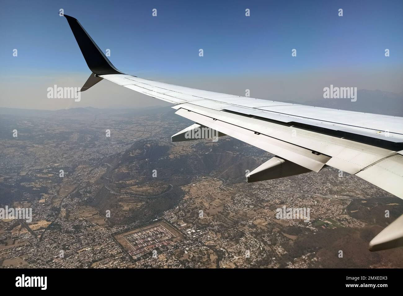 View through airplane window of commercial jet plane wing flying high ...