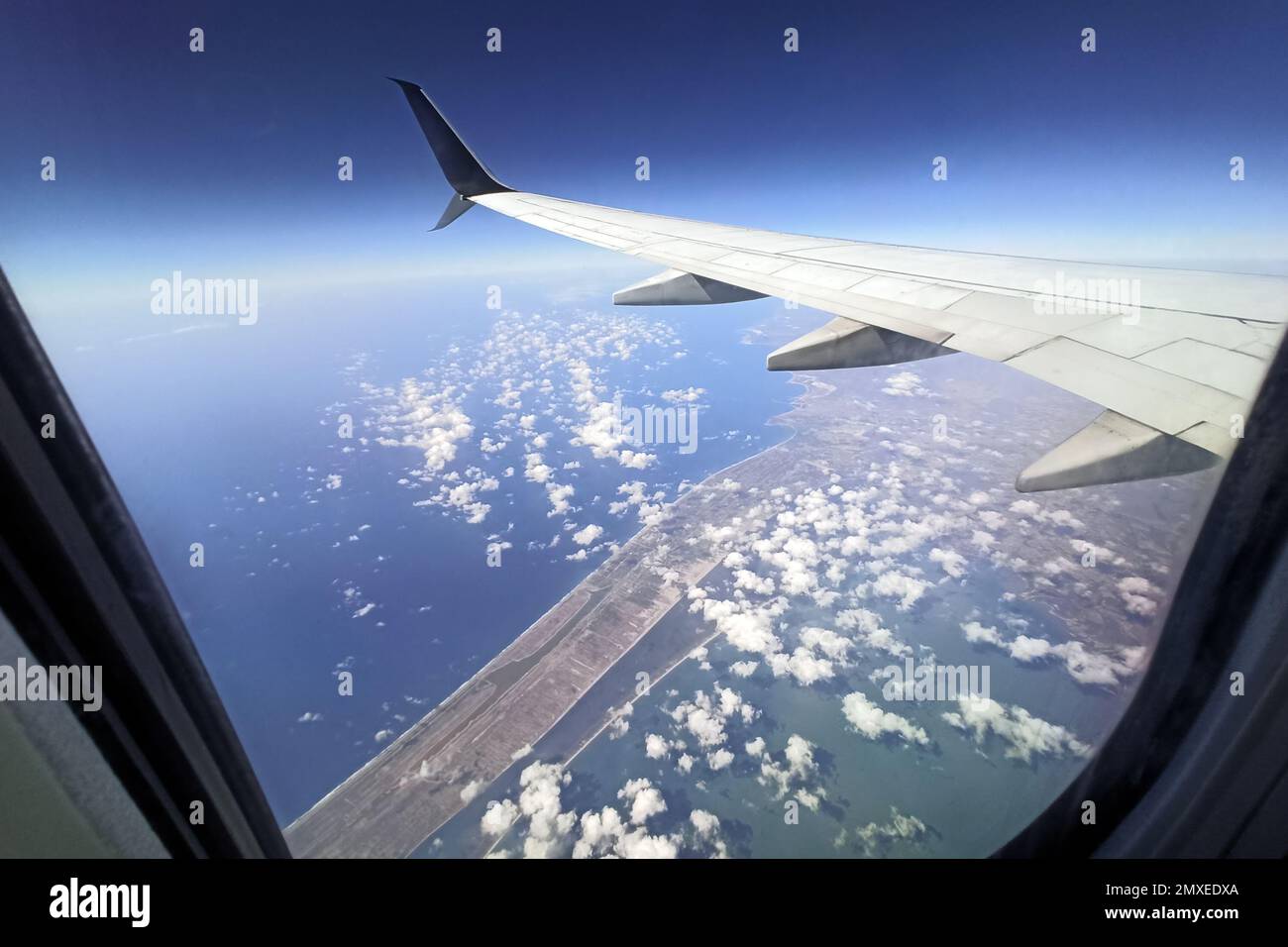 View through airplane window of commercial jet plane wing flying high ...