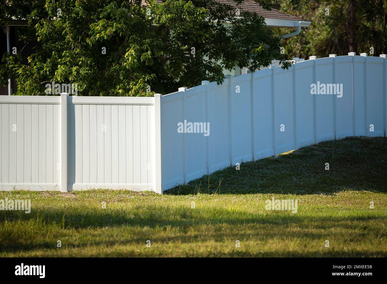 White plastic fence for back yard protection and privacy Stock Photo - Alamy