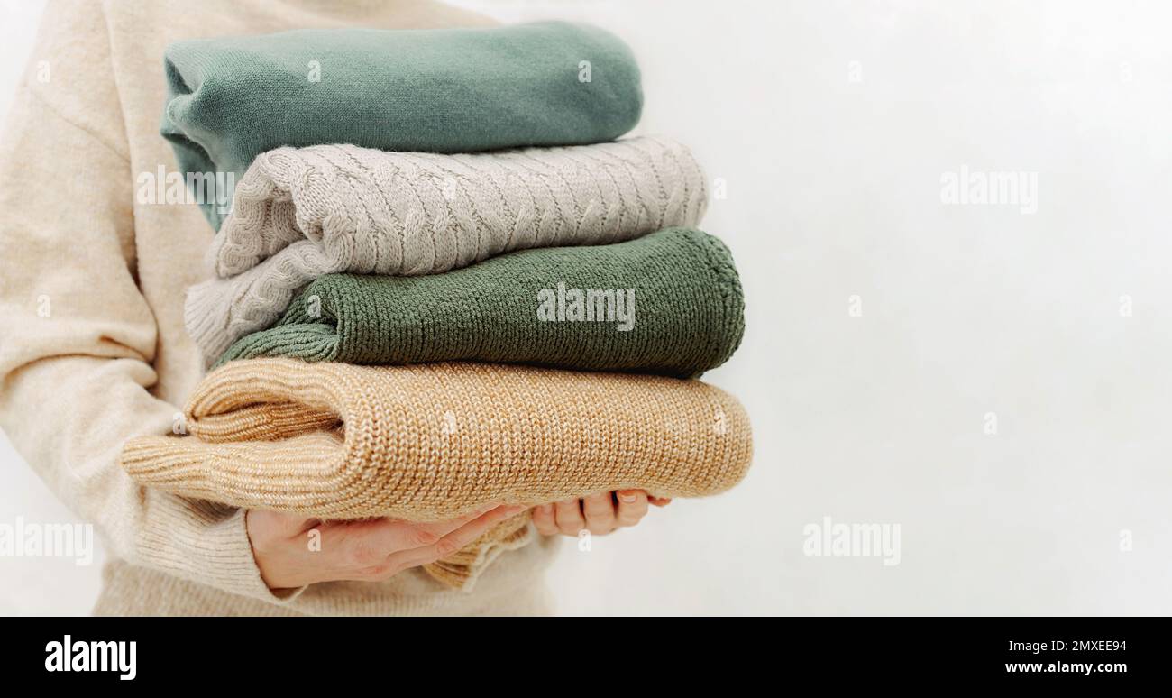 Woman's hand holding a stack of clothes. Clothes Donation, Renewable ...