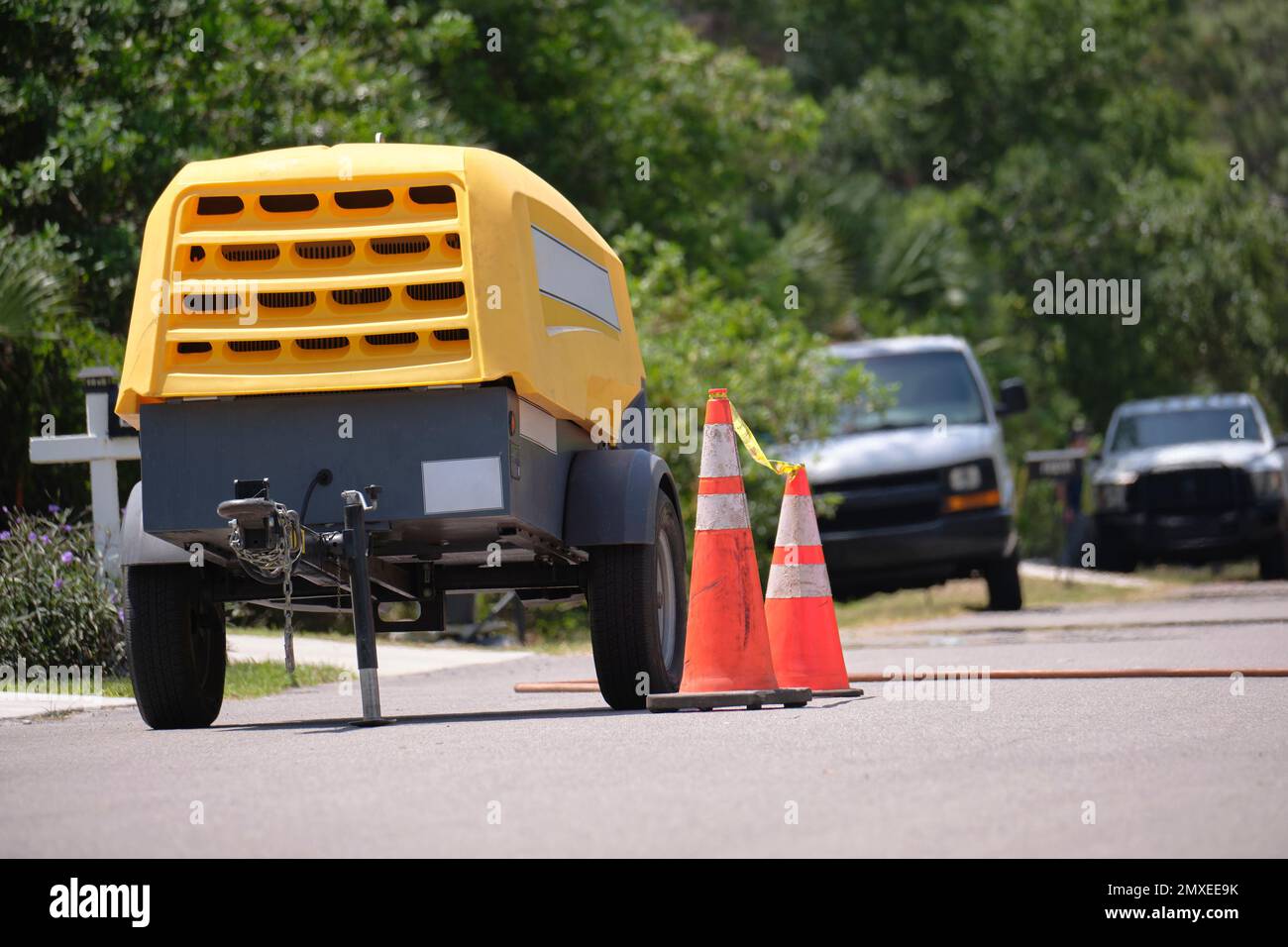 Yellow jackhammer machine with compressor trailer on road construction ...