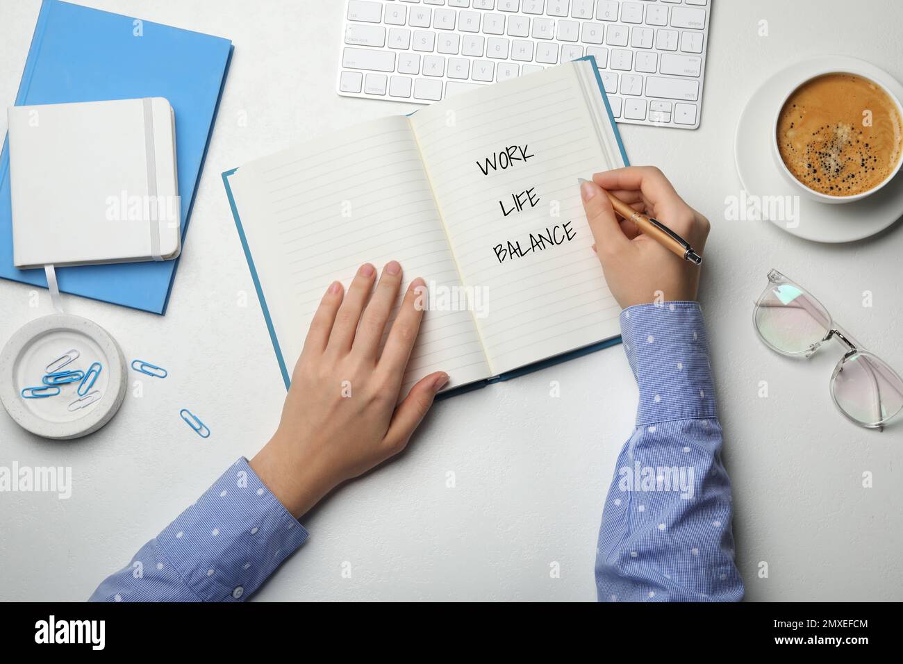 Work-life balance concept. Woman writing in notebook at white table ...