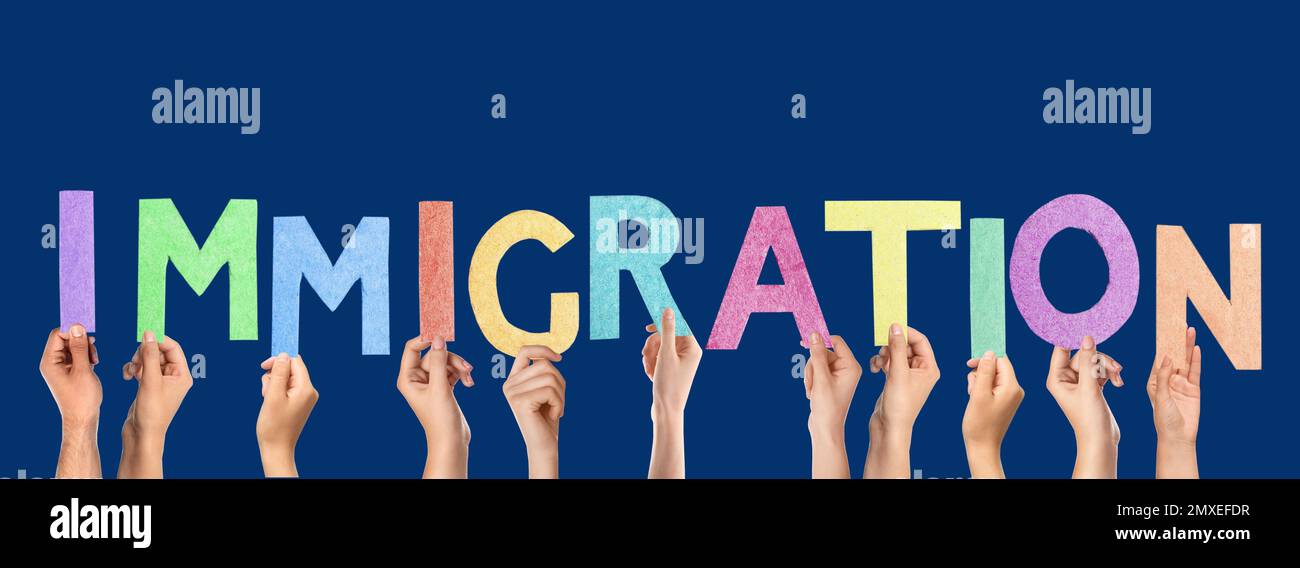 People holding word IMMIGRATION made of cardboard letters on blue ...