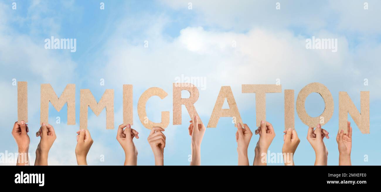 People holding word IMMIGRATION made of cardboard letters against blue ...