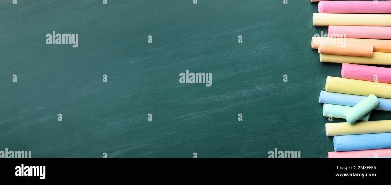 Pieces of color chalk on greenboard, flat lay with space for text ...