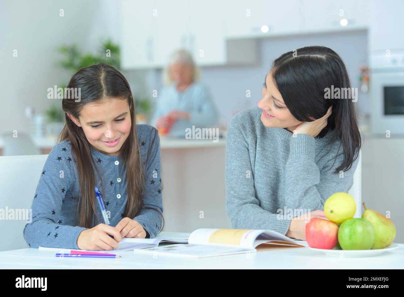 girl doing homework with mum Stock Photo - Alamy