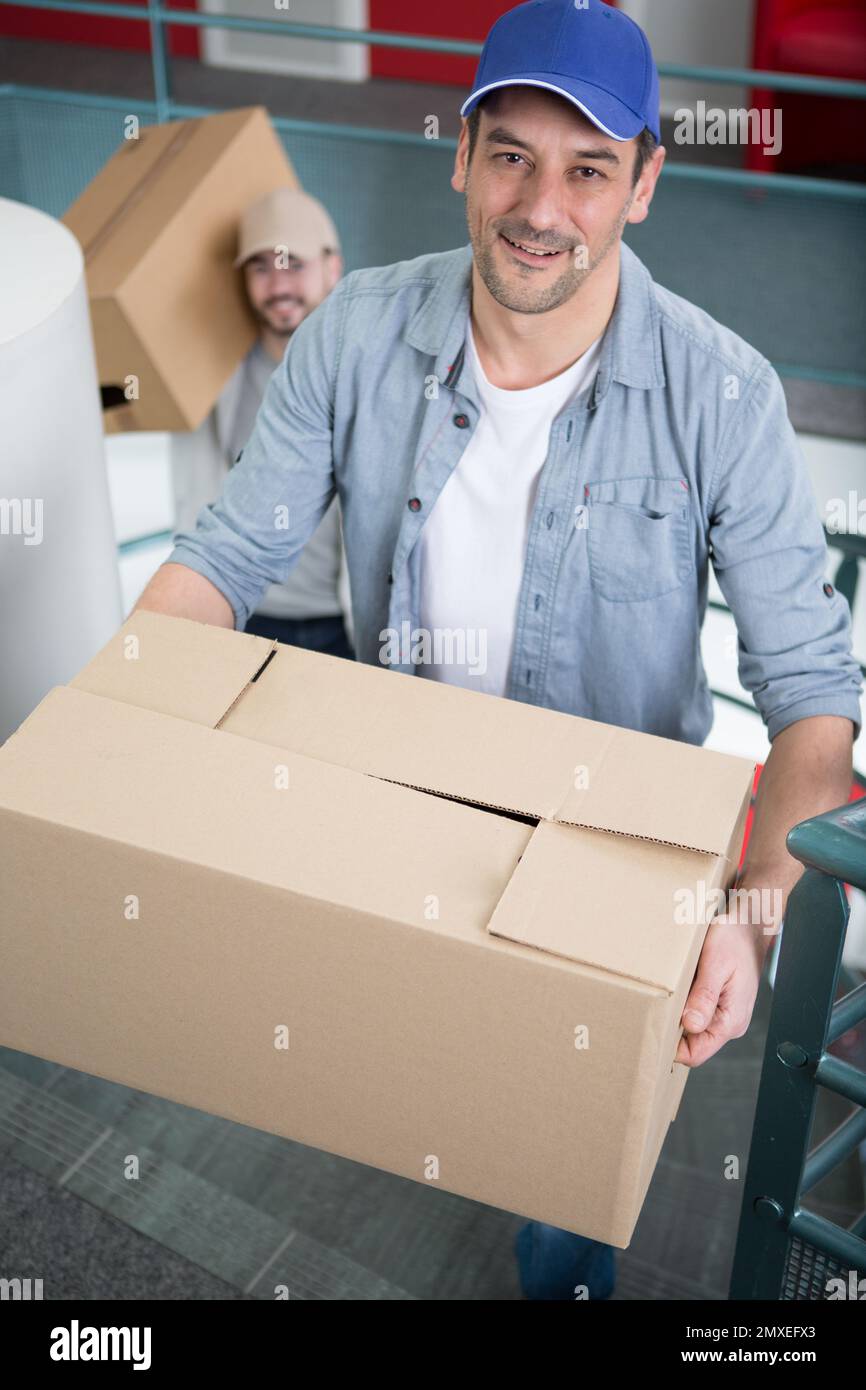movers carrying boxes on steps Stock Photo - Alamy