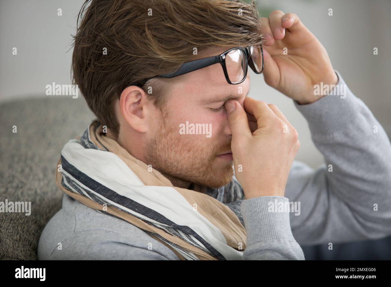 young businessman taking off glasses feels eye strain Stock Photo - Alamy