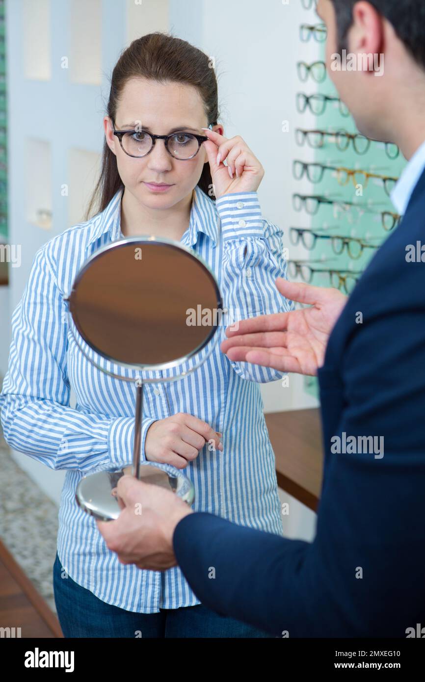woman trying on glasses in optical store Stock Photo - Alamy